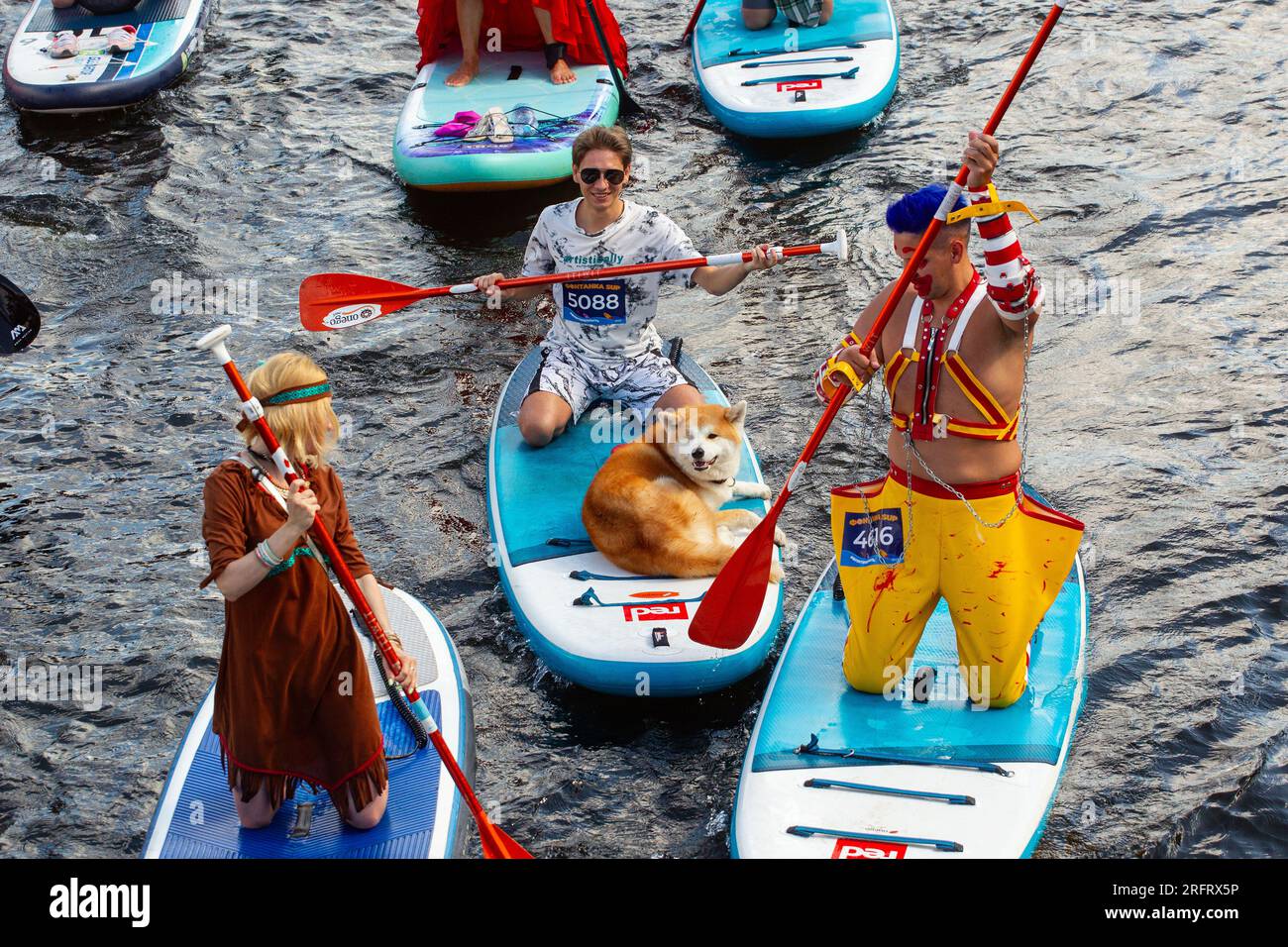 People dressed as various heroes and characters float on surfboards ...