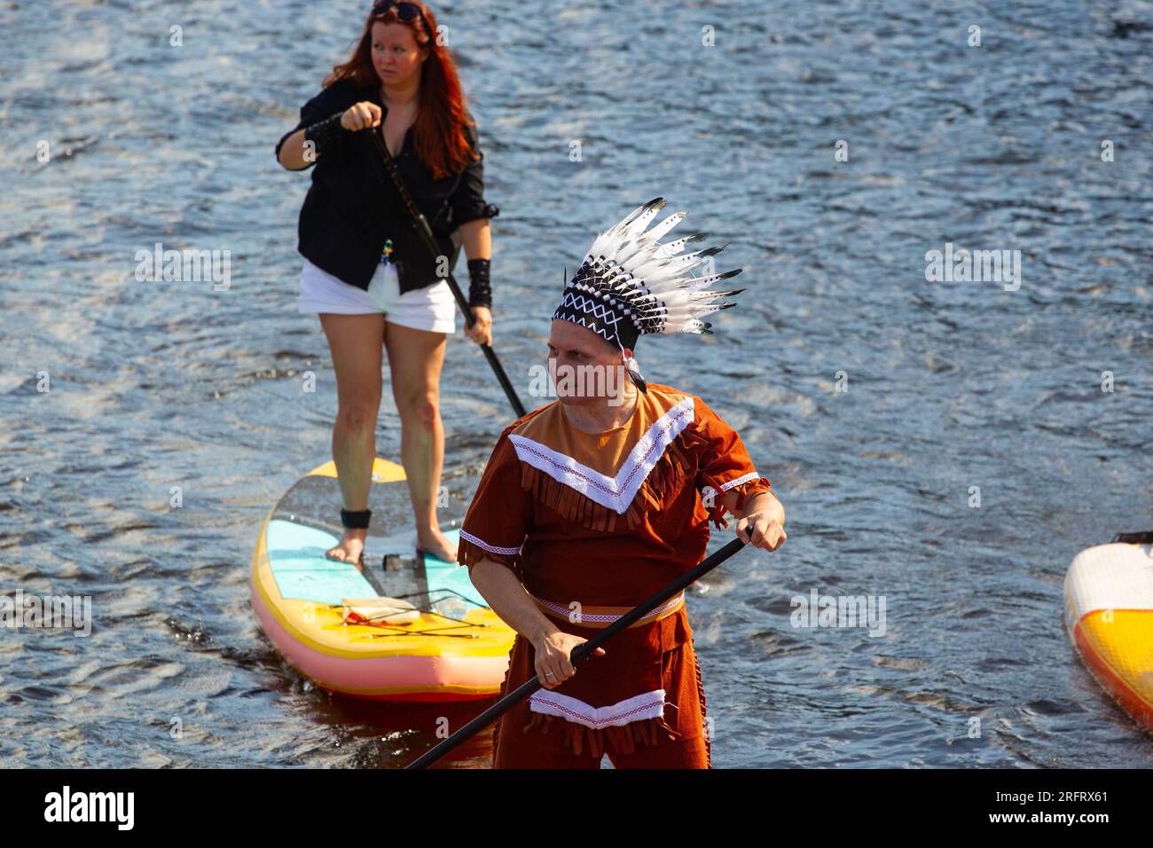 People dressed as various heroes and characters float on surfboards ...