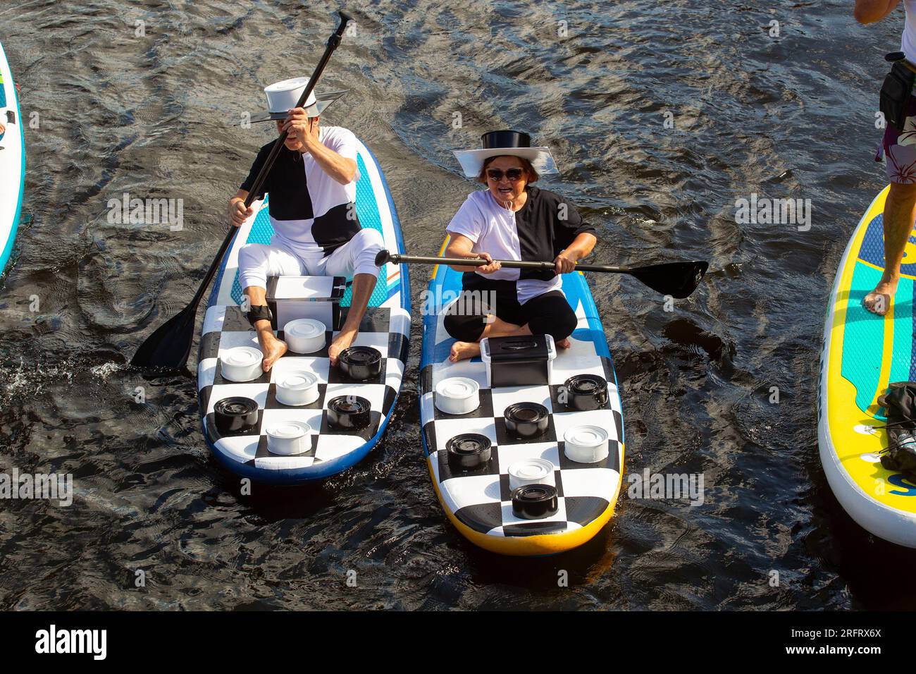 People dressed as various heroes and characters float on surfboards ...