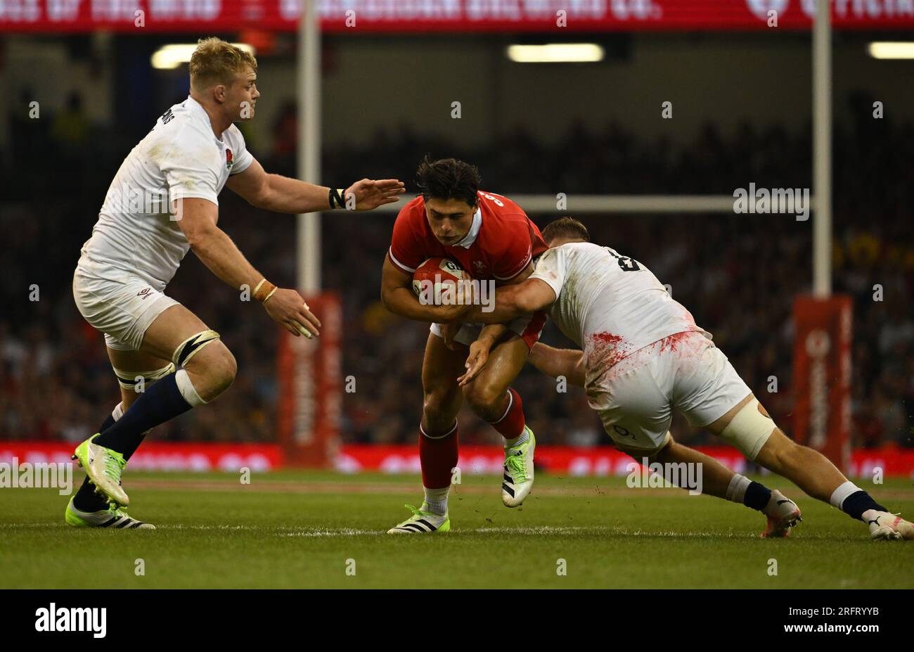 Wales' Louis Rees-Zammit (centre) is tackled by England's Dave Ribbans ...