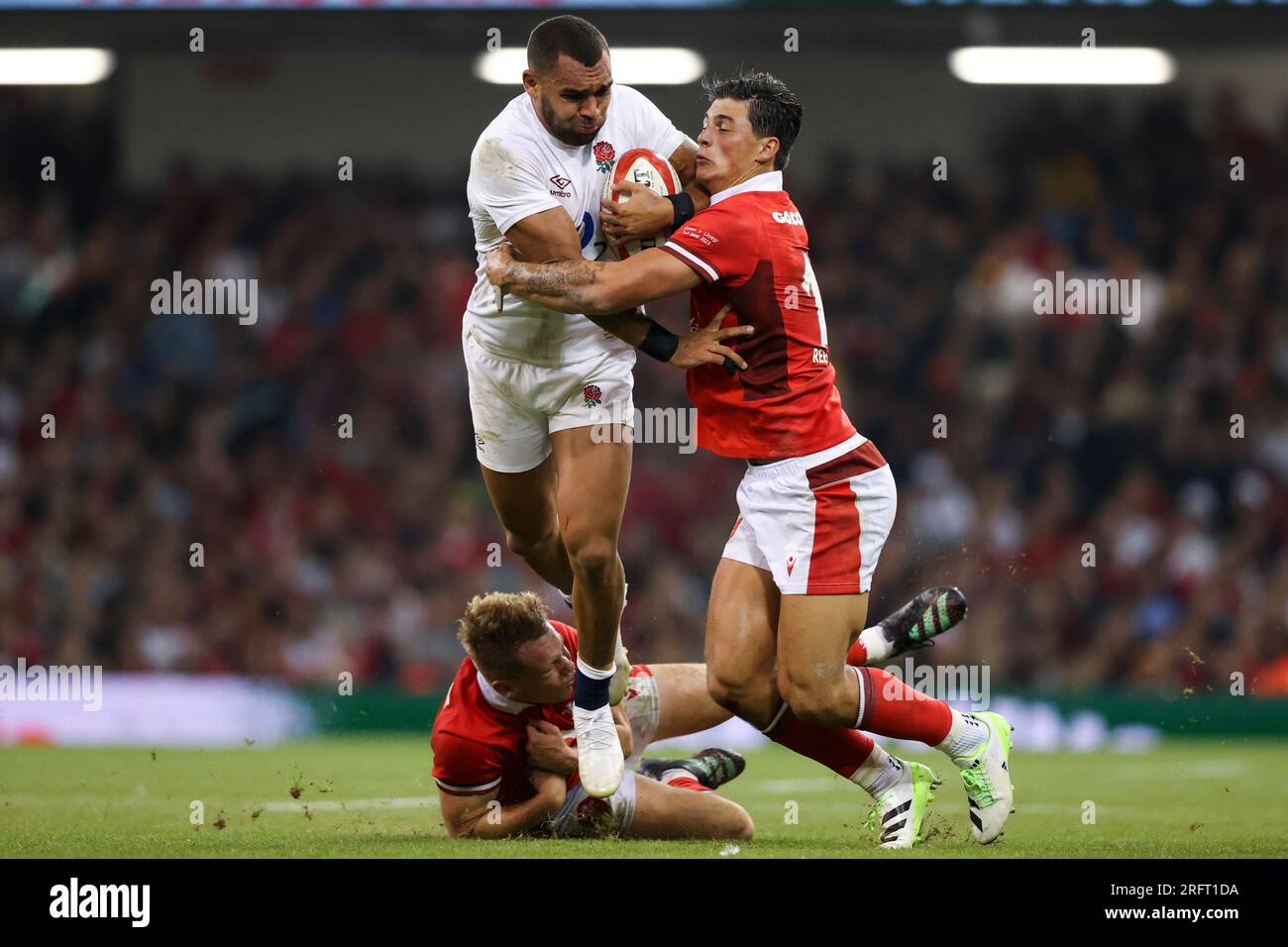 England's Joe Marchant is tackled by Wales' Sam Costelow and Louis Rees ...