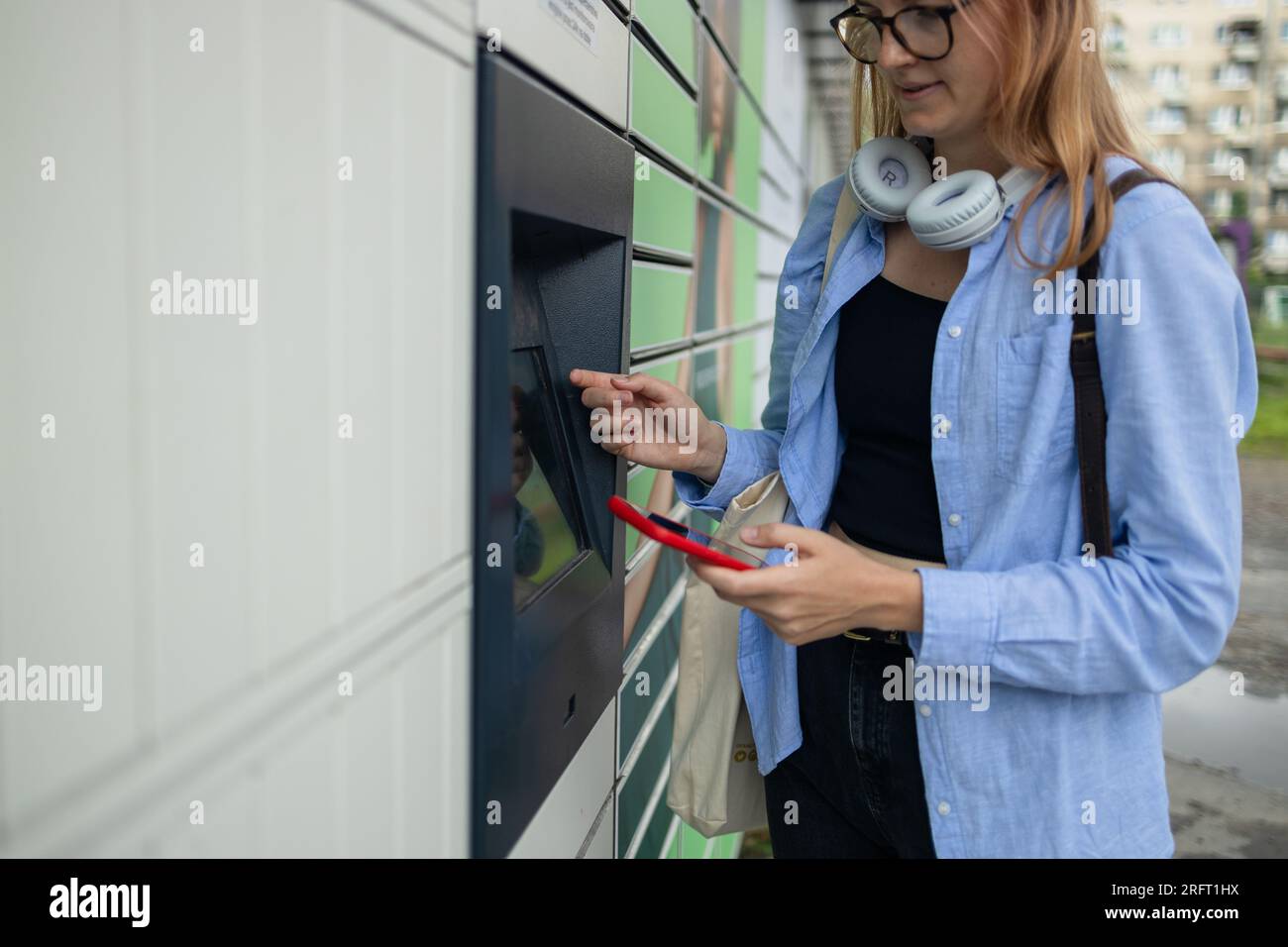 Woman client using automated self service post terminal machine or ...