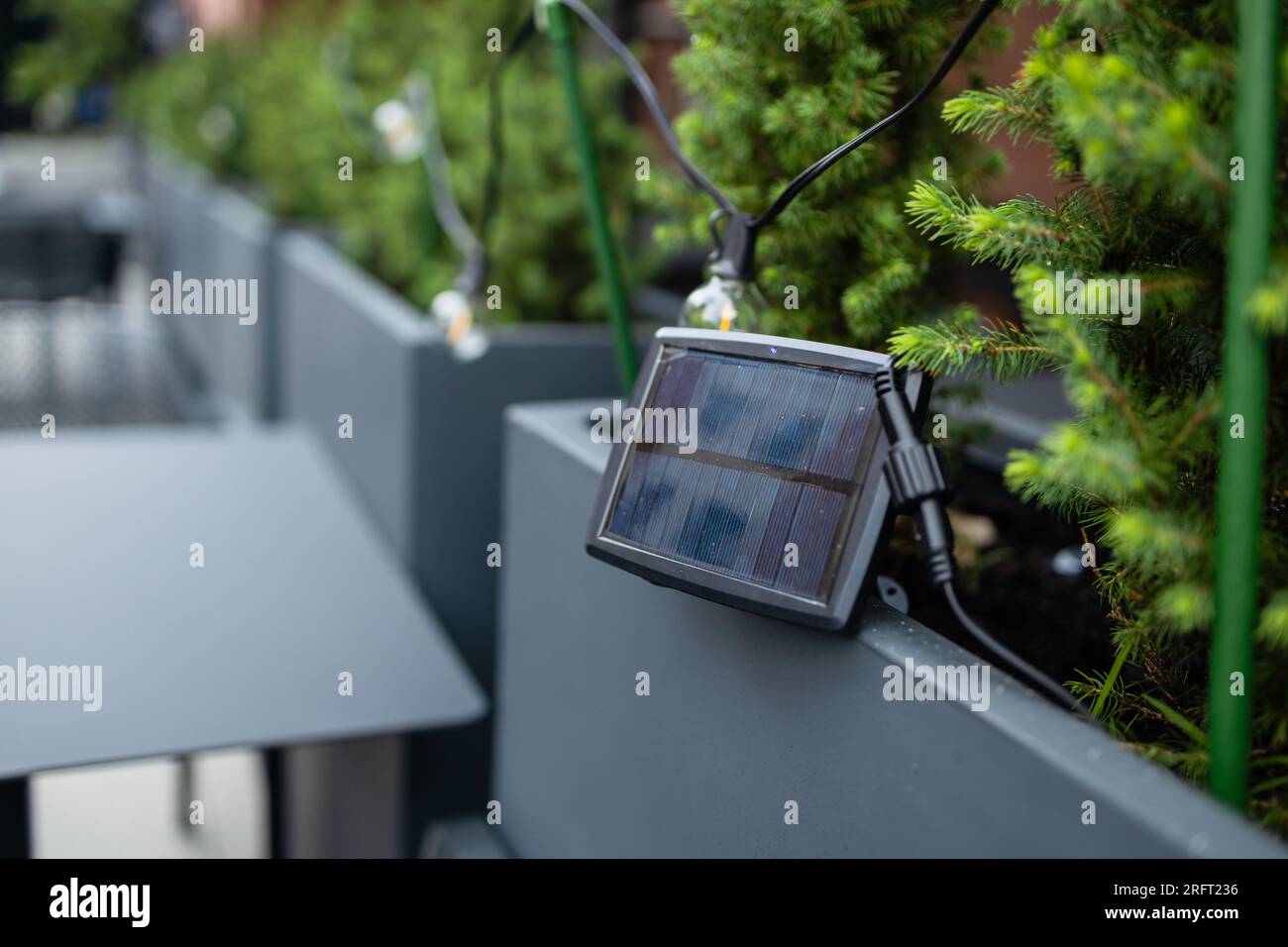 Small solar powered LED light is connected to a street decor garland at ...