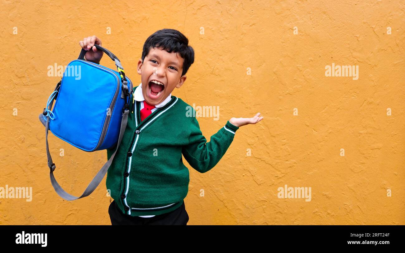 Dark-haired 9-year-old Latino boy in a school uniform shows off his new ...
