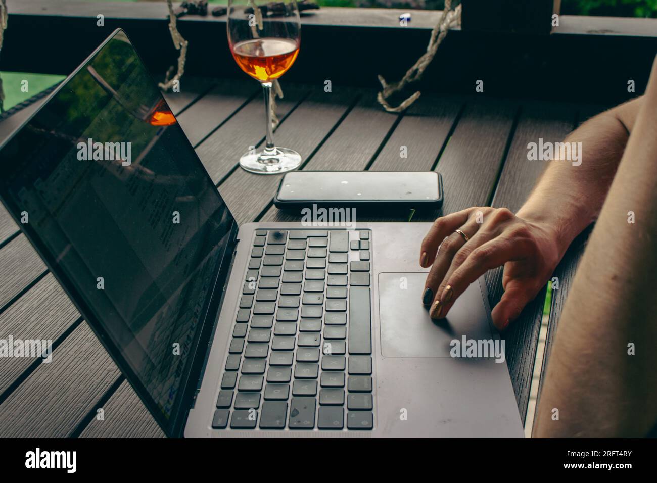 Girl typing on laptop with wineglass. Woman working on wireless ...