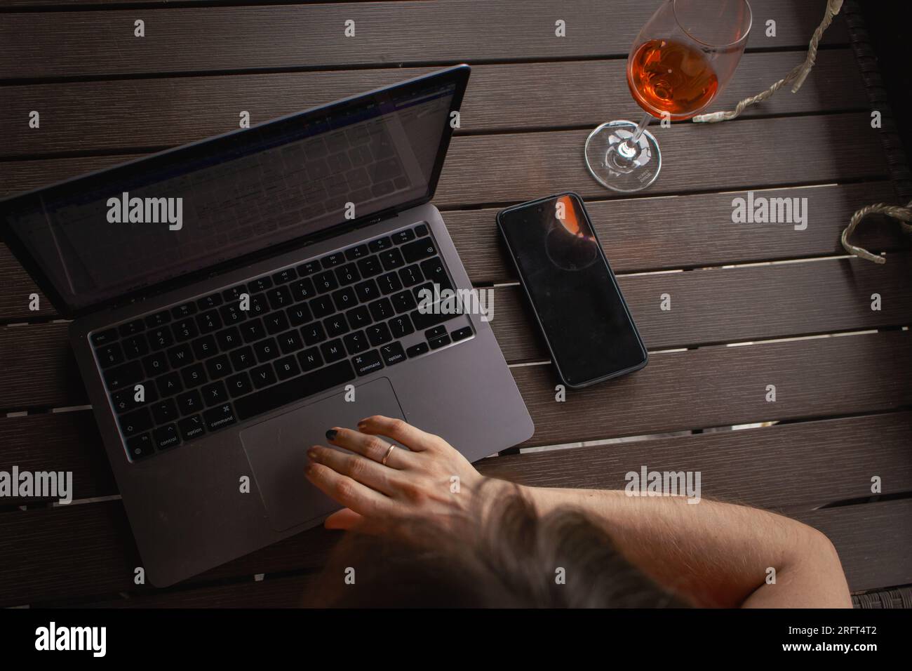 Girl typing on laptop with wineglass. Woman working on wireless ...