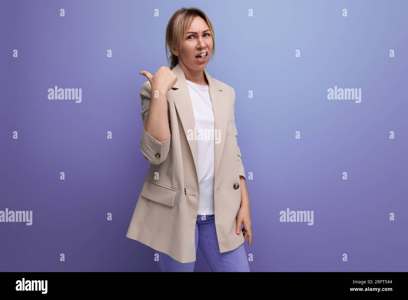 suspicious looking european young woman in a jacket on a studio ...