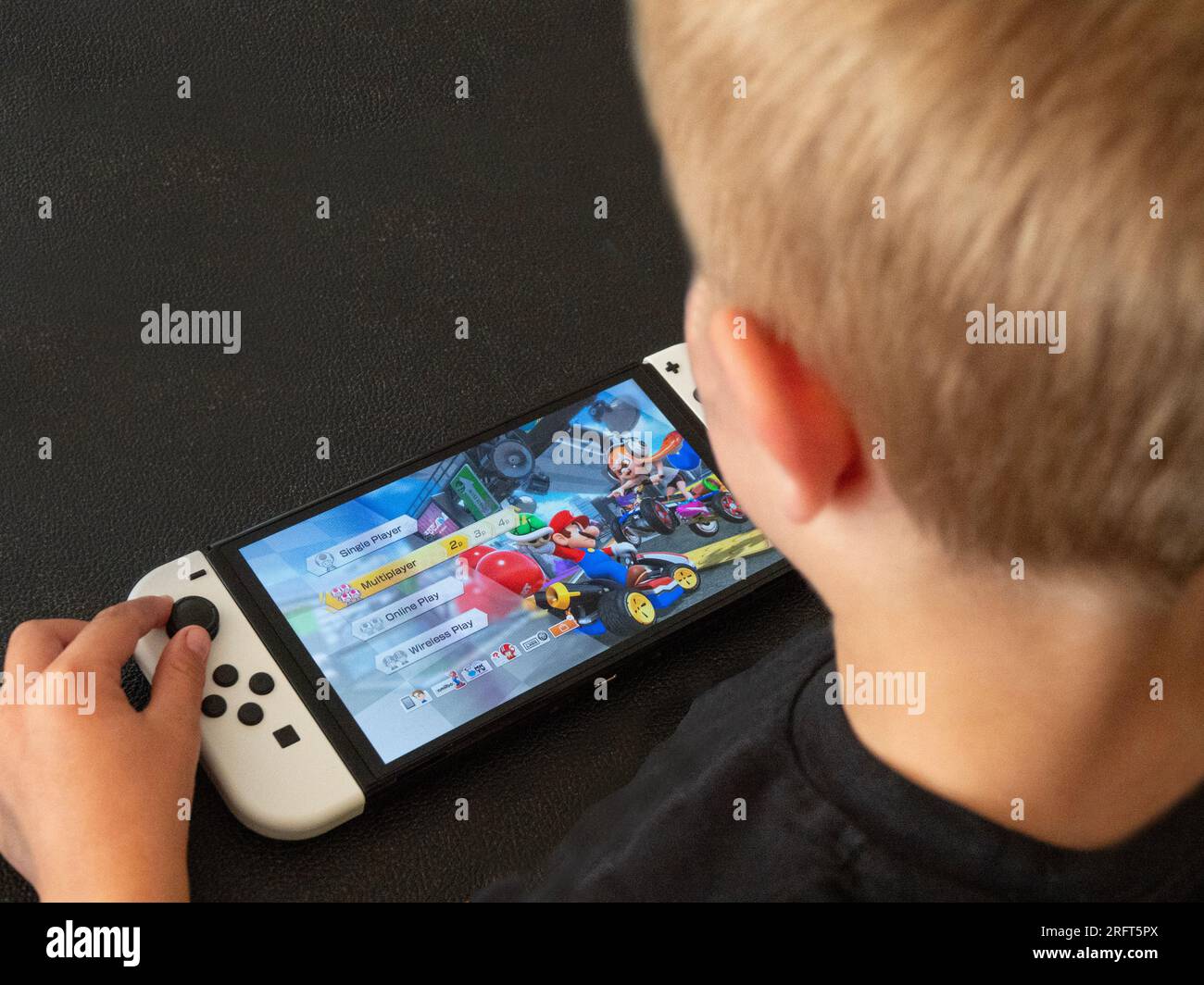 Young boy playing Mario Kart on a popular new Nintendo Switch console ...