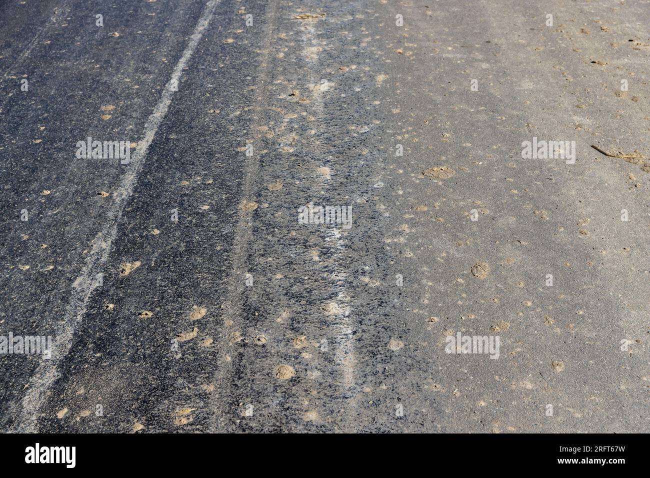 Details of a road polluted with sand and debris from fields, sand and ...