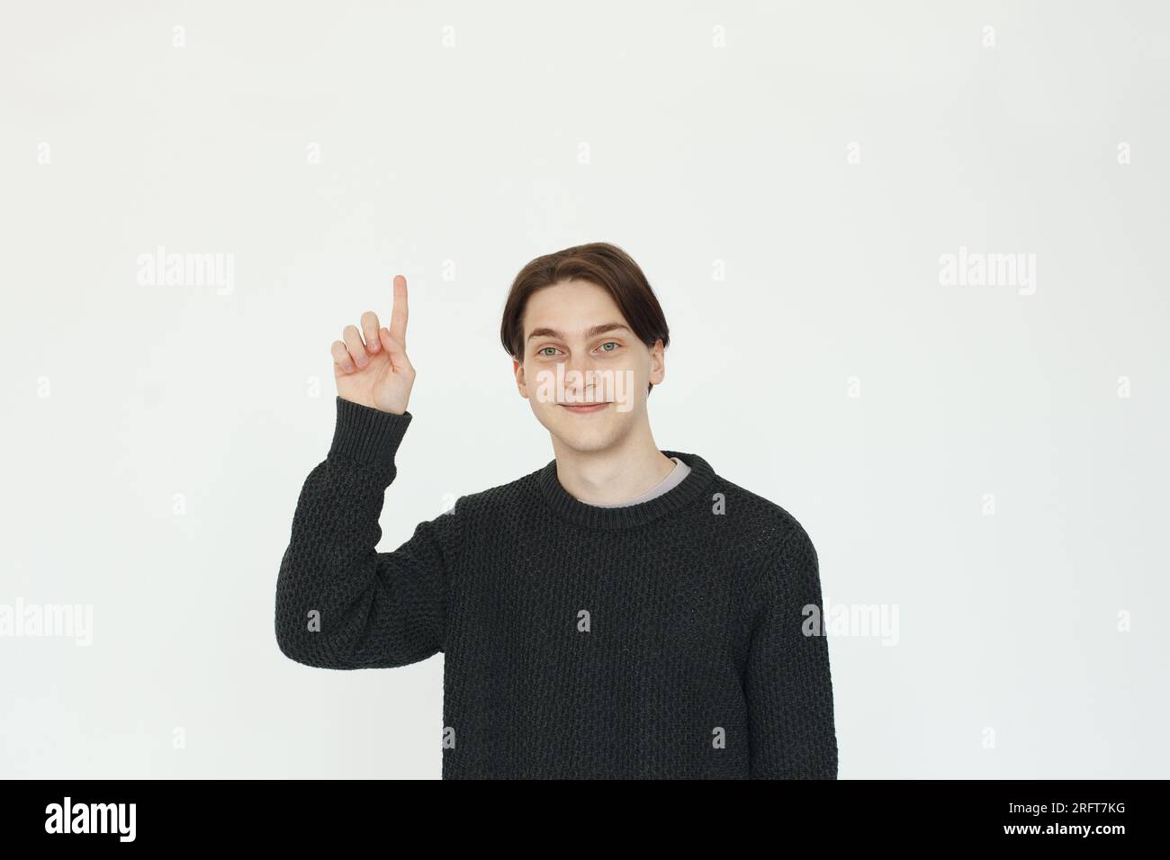 Handsome young man pointing finger up isolated on white background ...