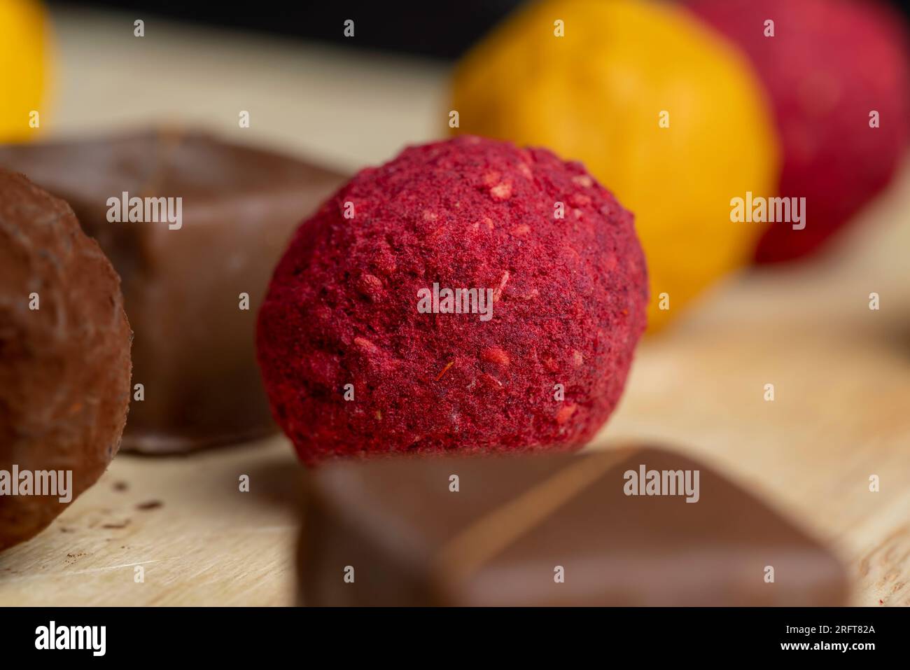 Red sweet candy in the shape of a ball on the table, chocolate candy ...