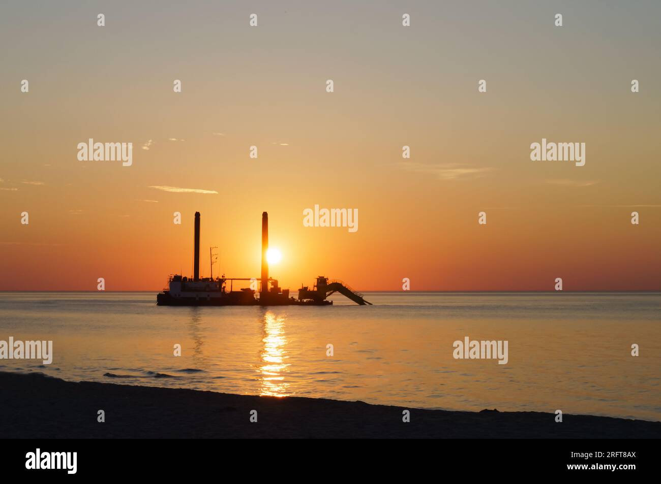 Dredging vessel. The technique deepens the seabed. Sunset at sea and ...