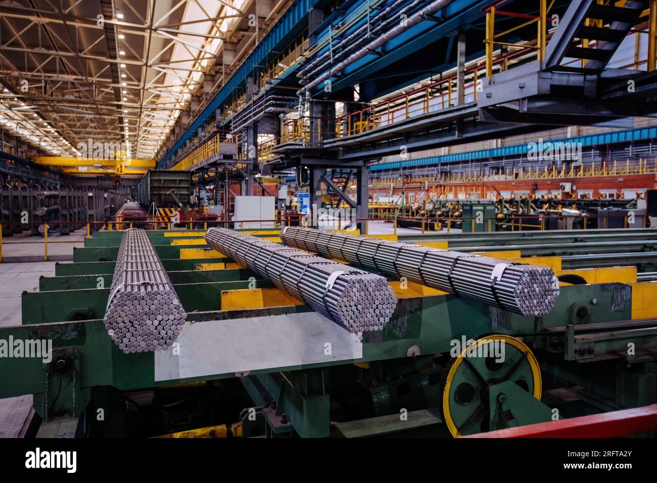 Packs of rolled metal bars on roller conveyor Stock Photo - Alamy