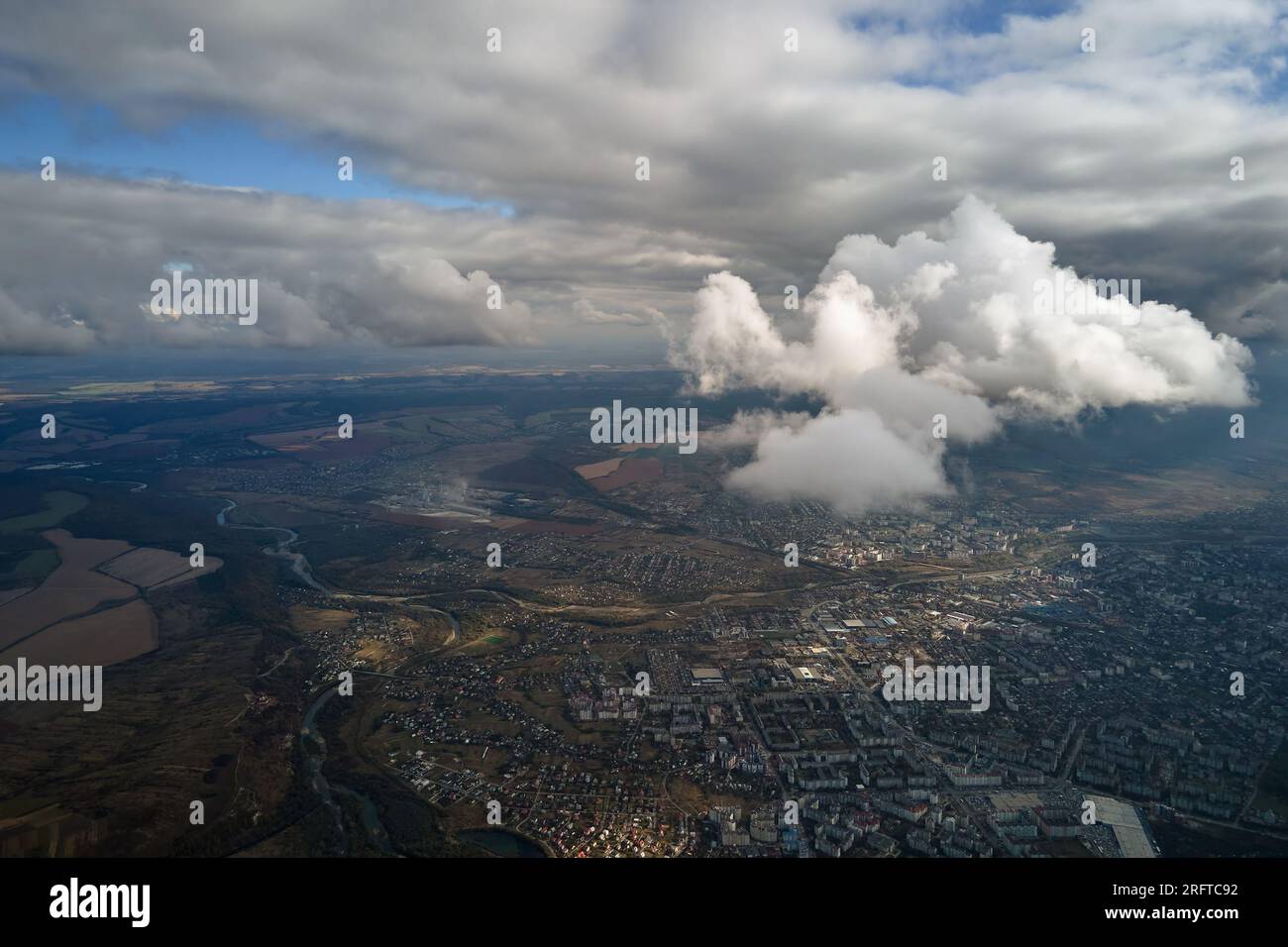 Aerial view from airplane window at high altitude of distant city ...