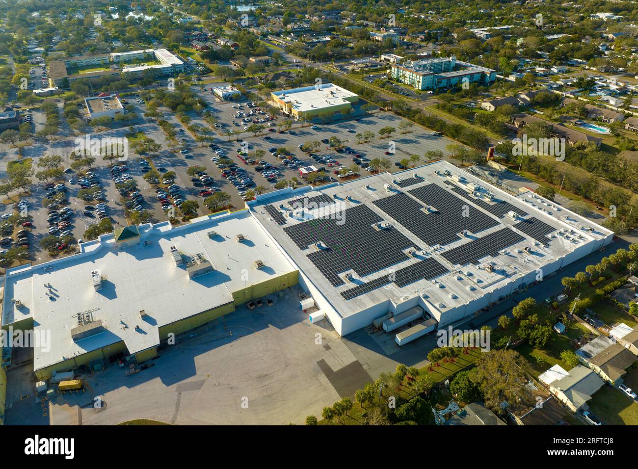 Aerial view of blue photovoltaic solar panels mounted on shopping mall ...