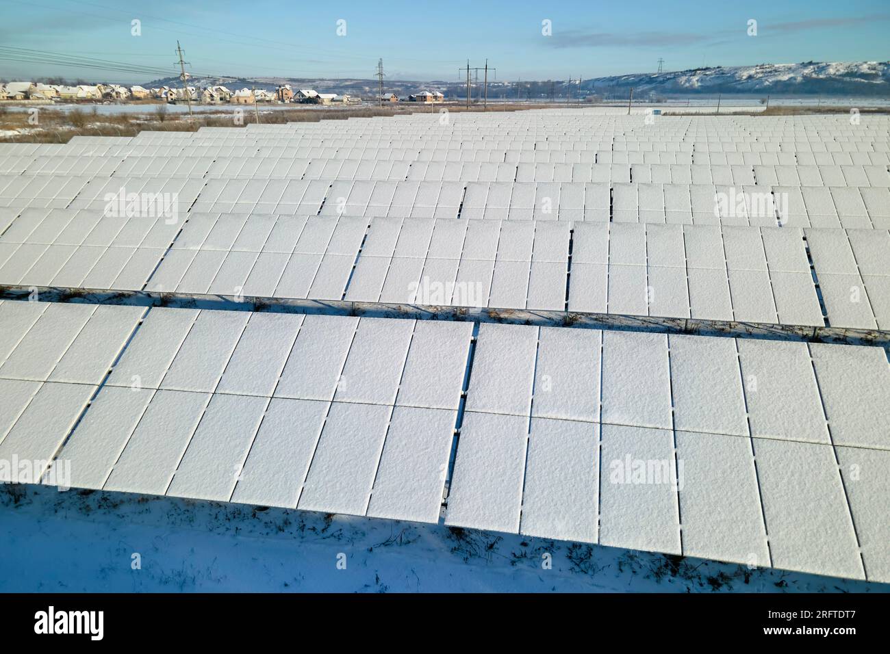 Aerial view of snow covered sustainable electric power plant with rows ...