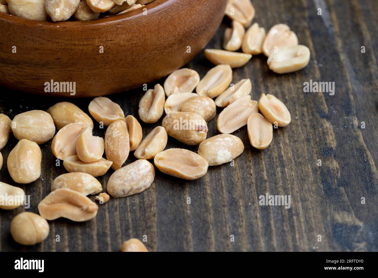 Peeled and roasted peanuts on the table, a pile of whole and half ...