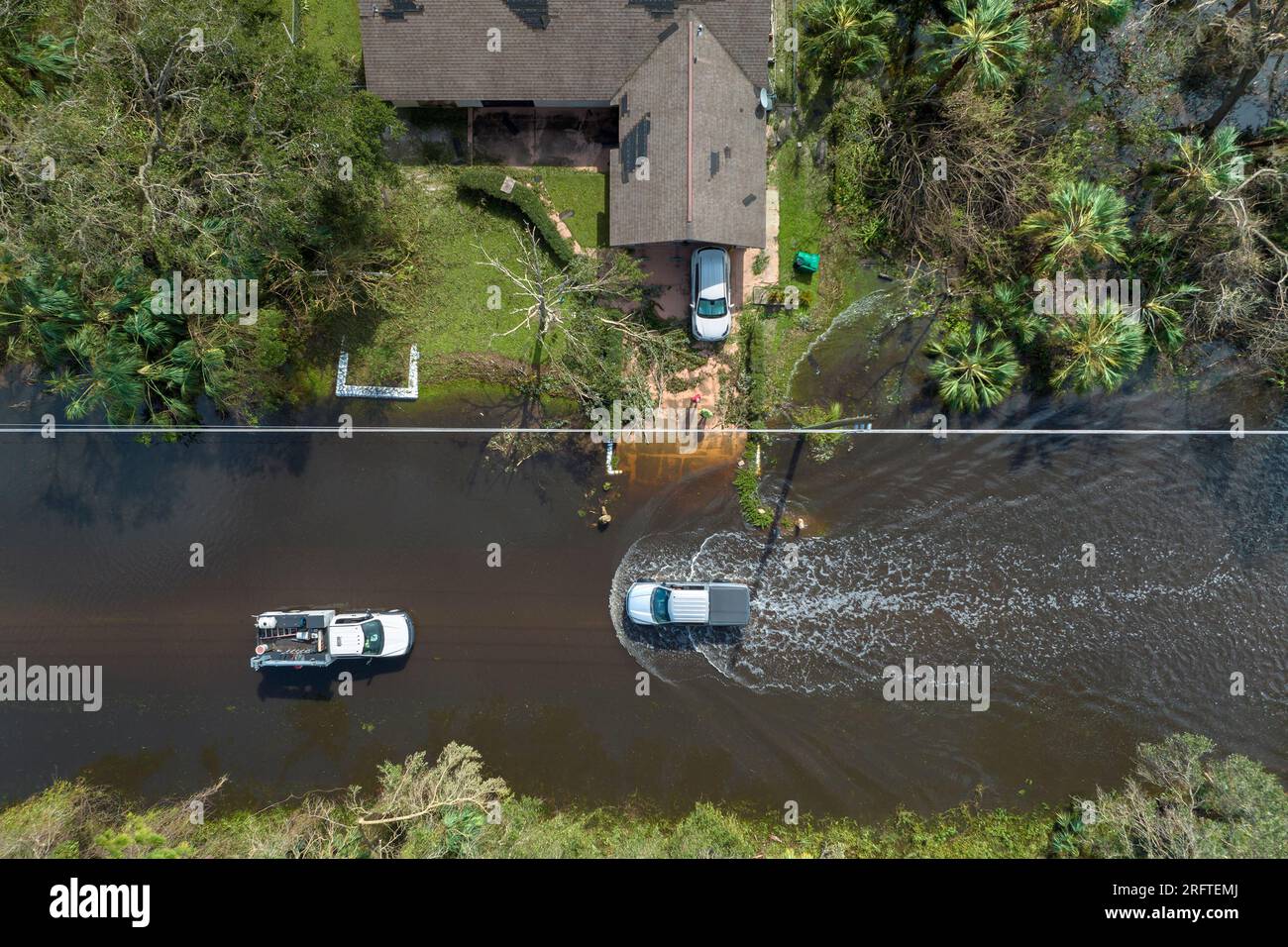 Hurricane Ian flooded street with moving cars and surrounded with water ...