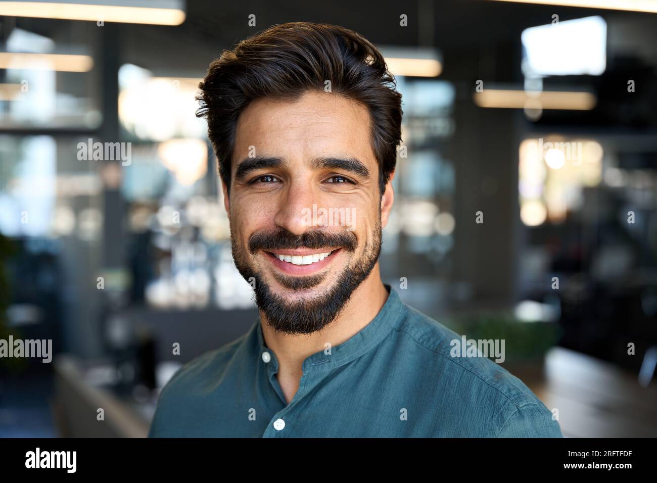 Happy young Latin business man looking at camera in office, headshot ...
