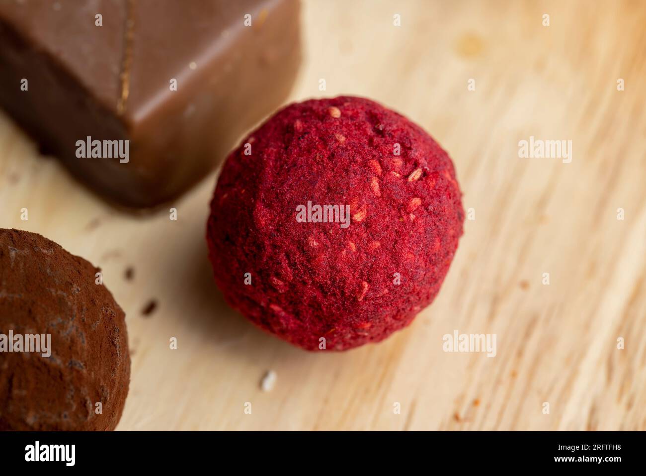 Red sweet candy in the shape of a ball on the table, chocolate candy ...