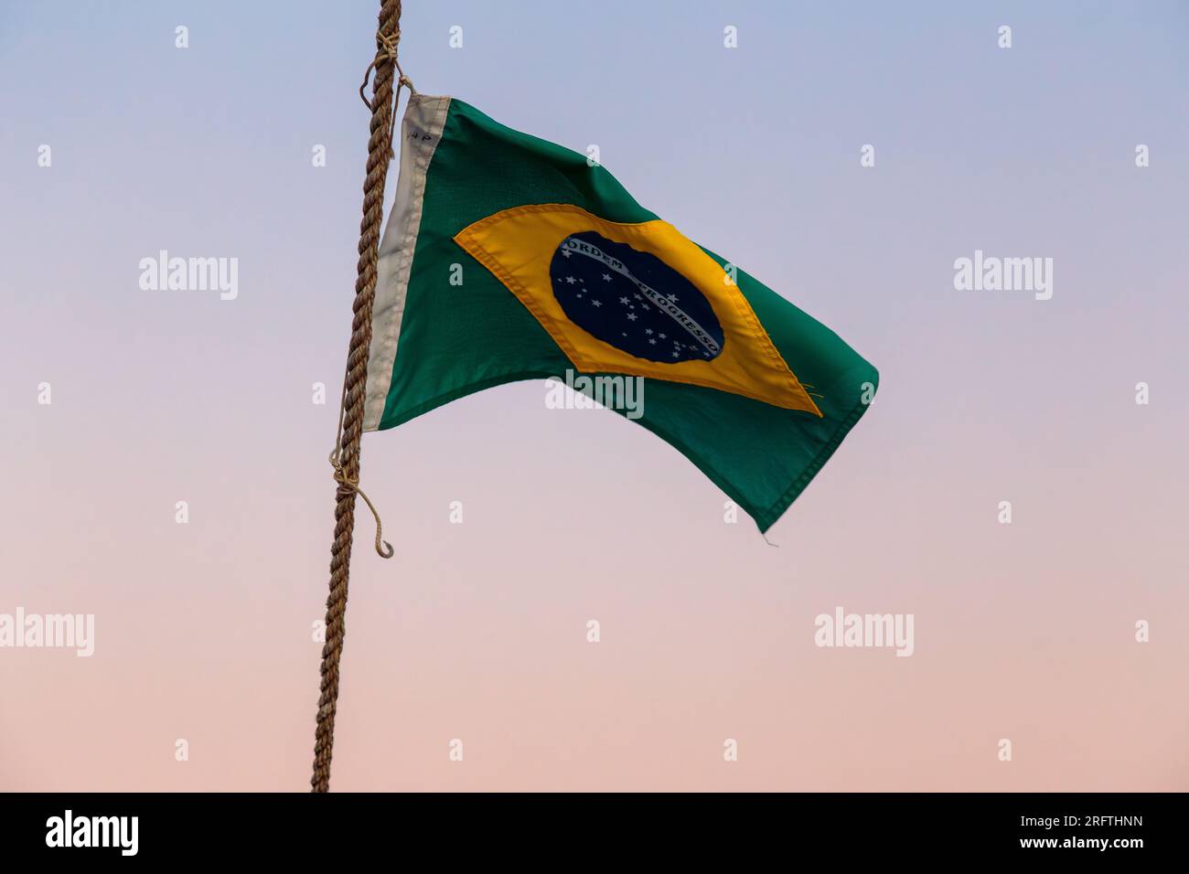 flag of brazil outdoors with a beautiful colorful sunset sky in Rio de ...
