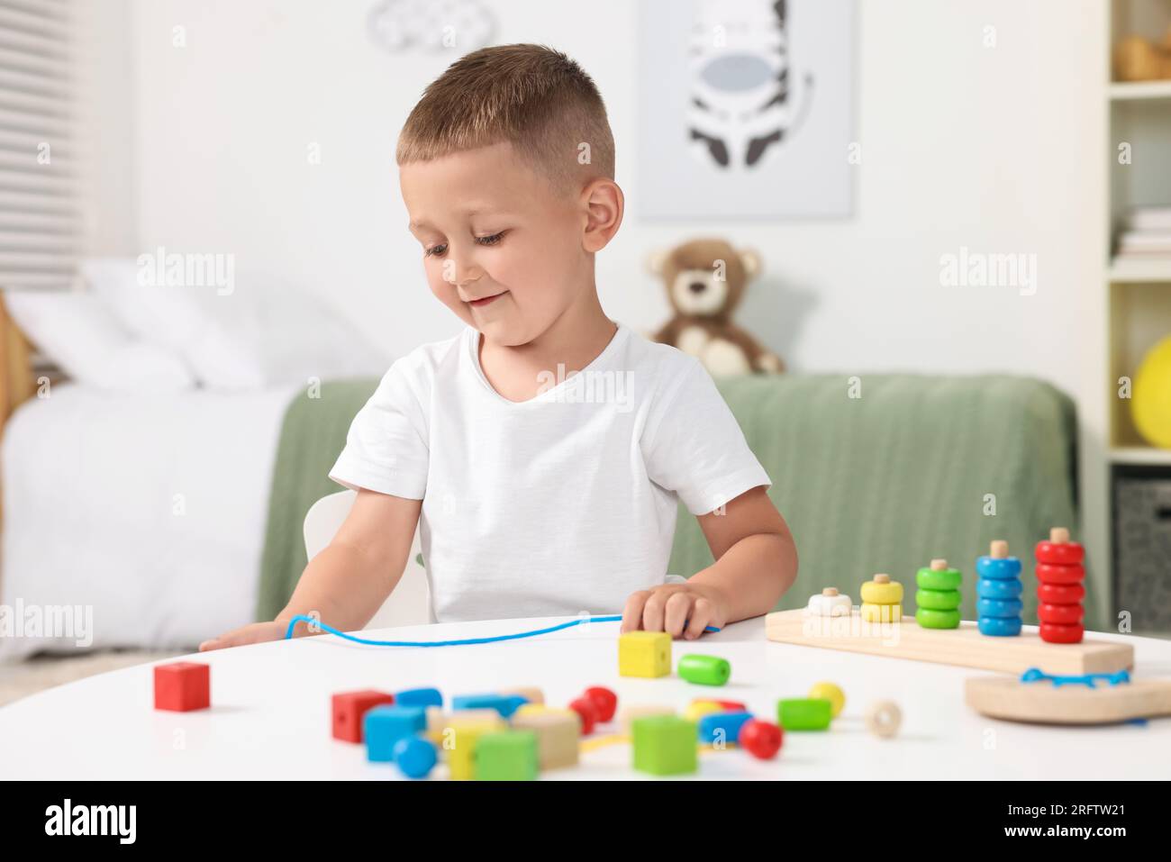 Motor skills development. Little boy playing with wooden pieces and ...