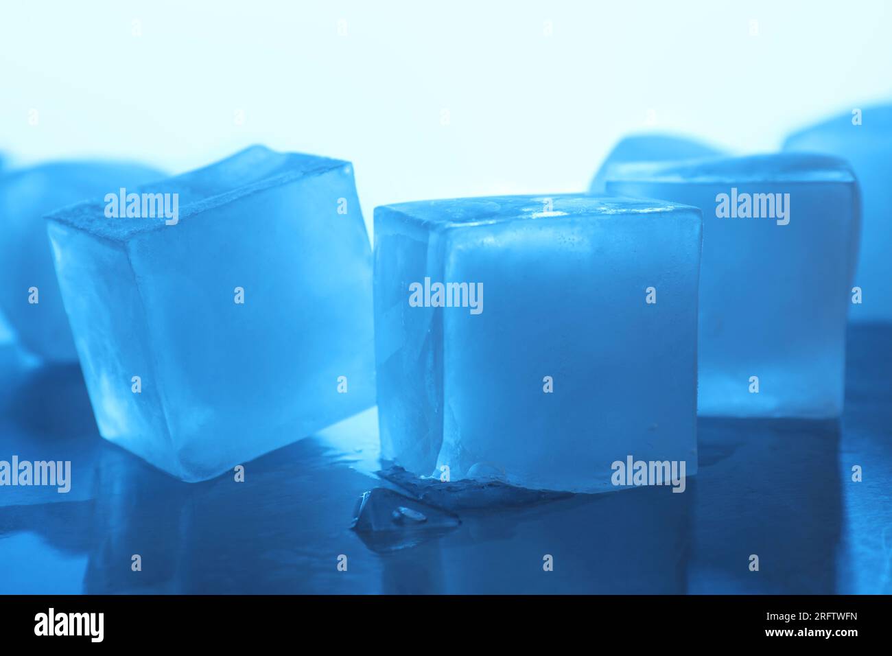 Crystal clear ice cubes on light blue background, closeup. Color tone effect Stock Photo - Alamy