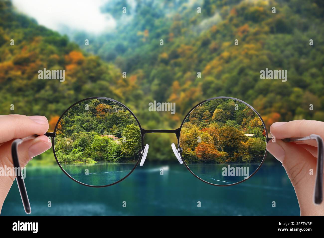 Vision correction. Woman looking through glasses and seeing landscape ...