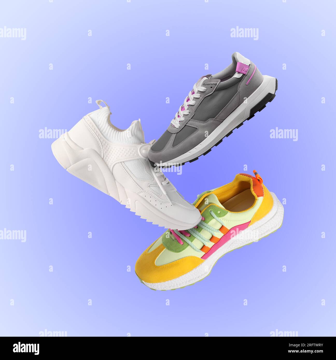 Different sneakers falling on blue gradient background Stock Photo - Alamy