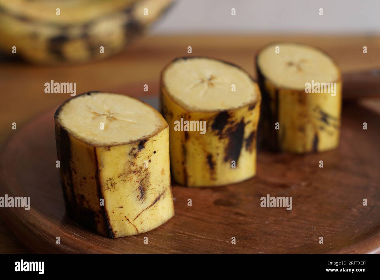 Cut ripe plantains on a clay plate Stock Photo - Alamy