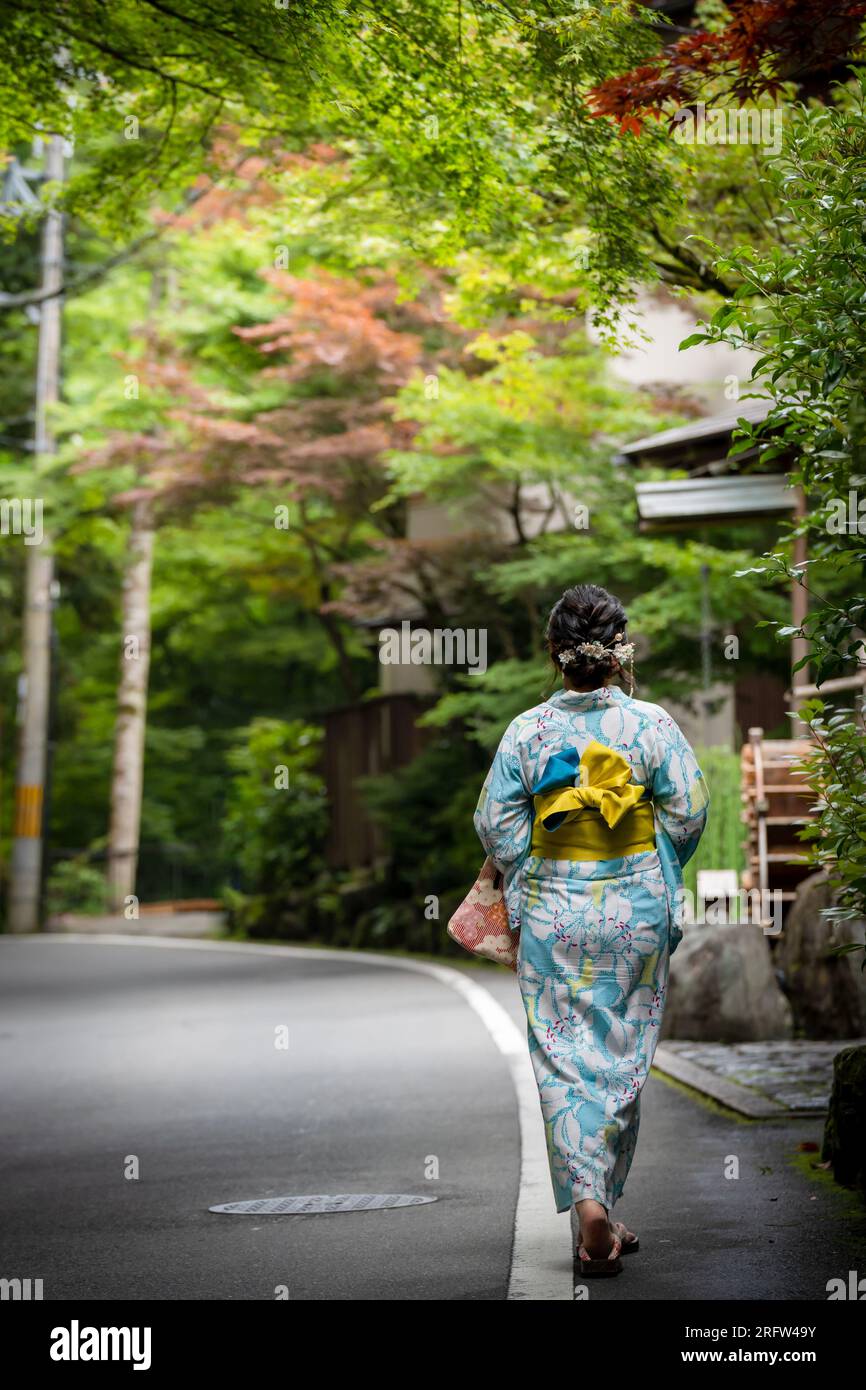 Back view of two women wearing Japanese yukata summer kimono walking on ...