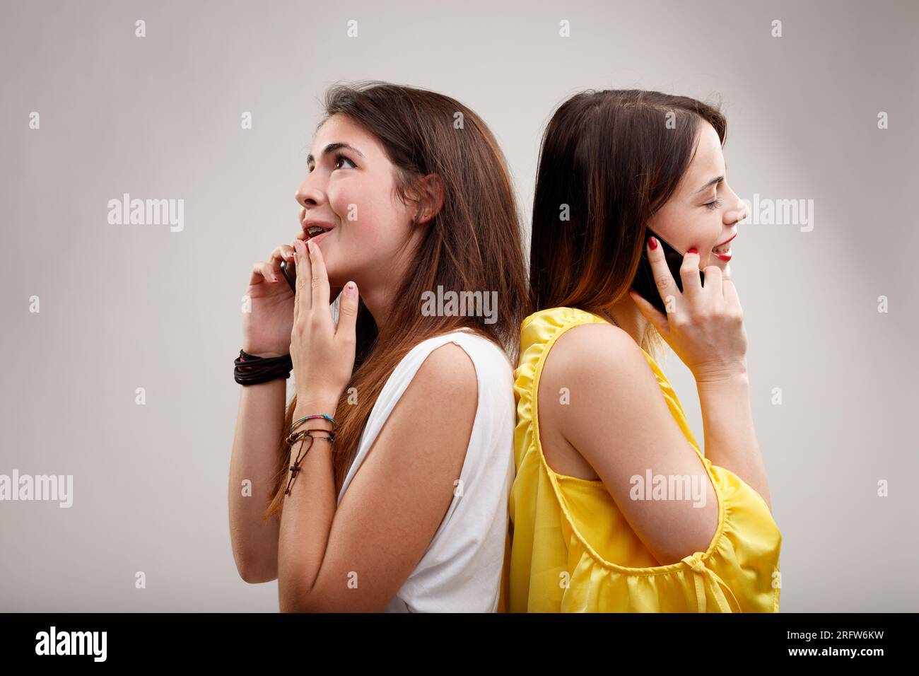 young woman shares spicy gossip with another, mocking others and ...