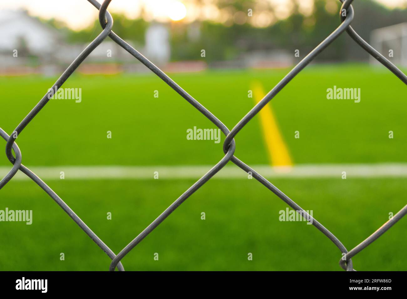 A soccer field view from outside the fence, focusing on the fence ...