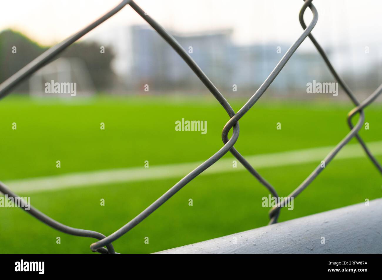 A soccer field view from outside the fence, focusing on the fence ...