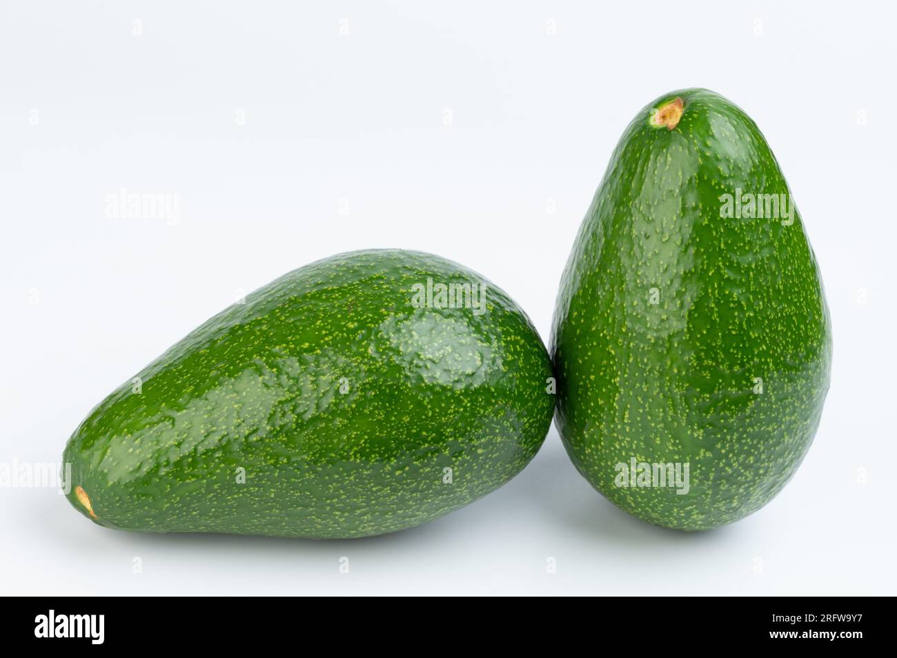 Pair of green fresh avocados macro close up view isolated on white ...