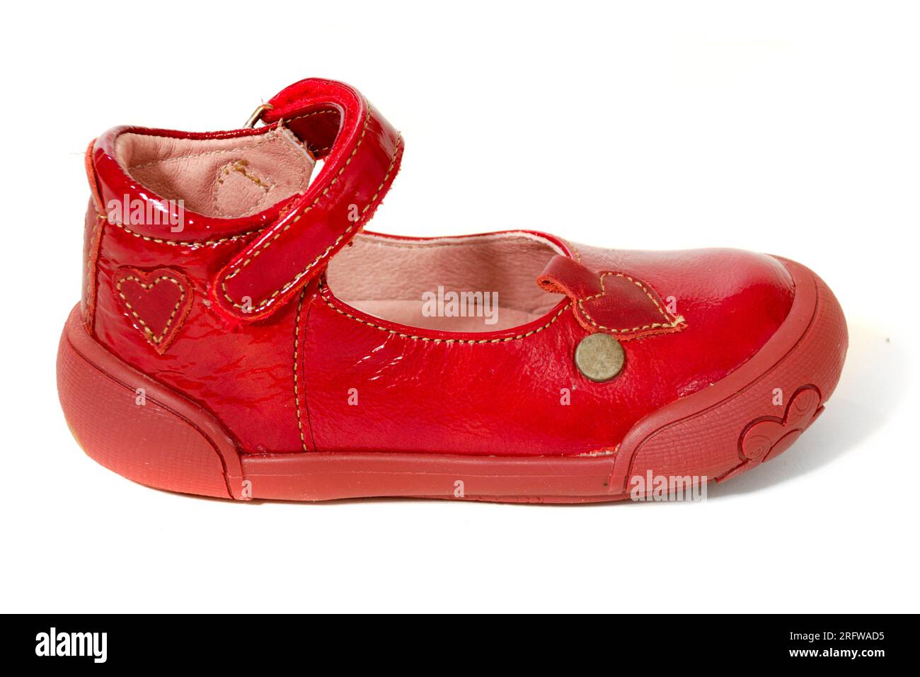 A red childs shoe. Taken on a clean white background Stock Photo - Alamy