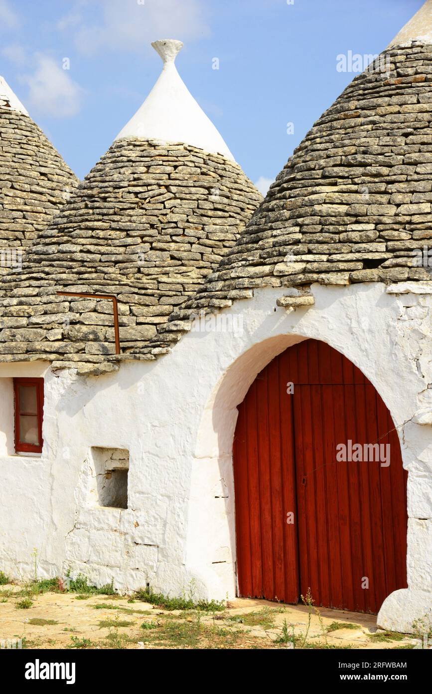 ITALY. PUGLIA. ALBEROBELLO. TRULLO, TYPICAL STONE HOUSE, WITH A RED ...