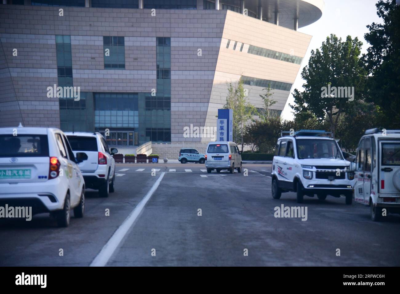DEZHOU, CHINA - AUGUST 6, 2023 - Vehicles parked on the street outside ...