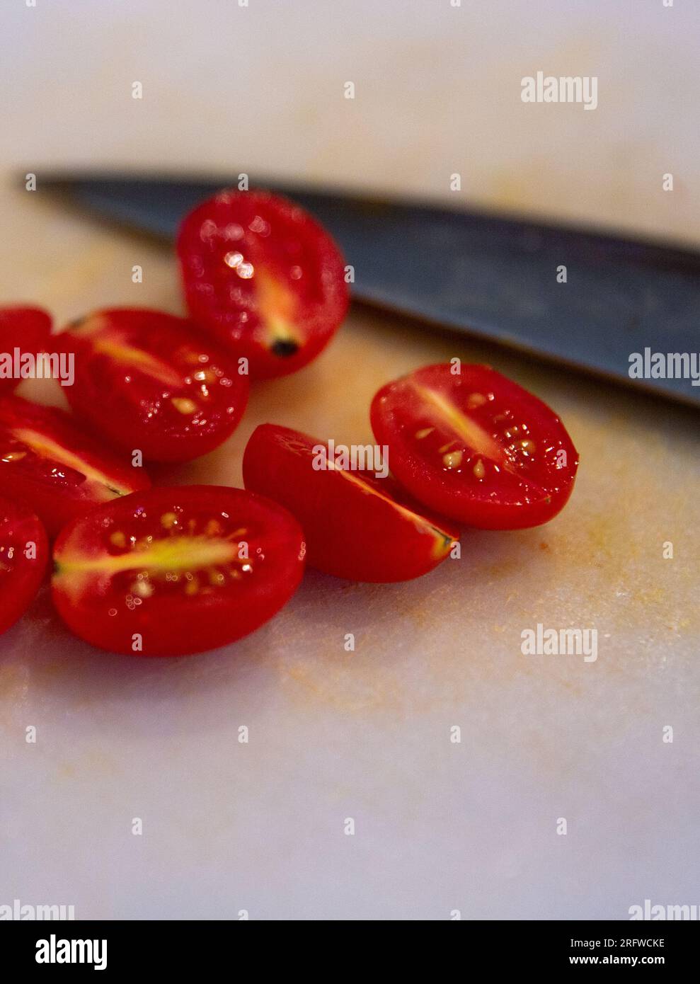 Knife next sliced tomatoes to be used as a topping Stock Photo - Alamy