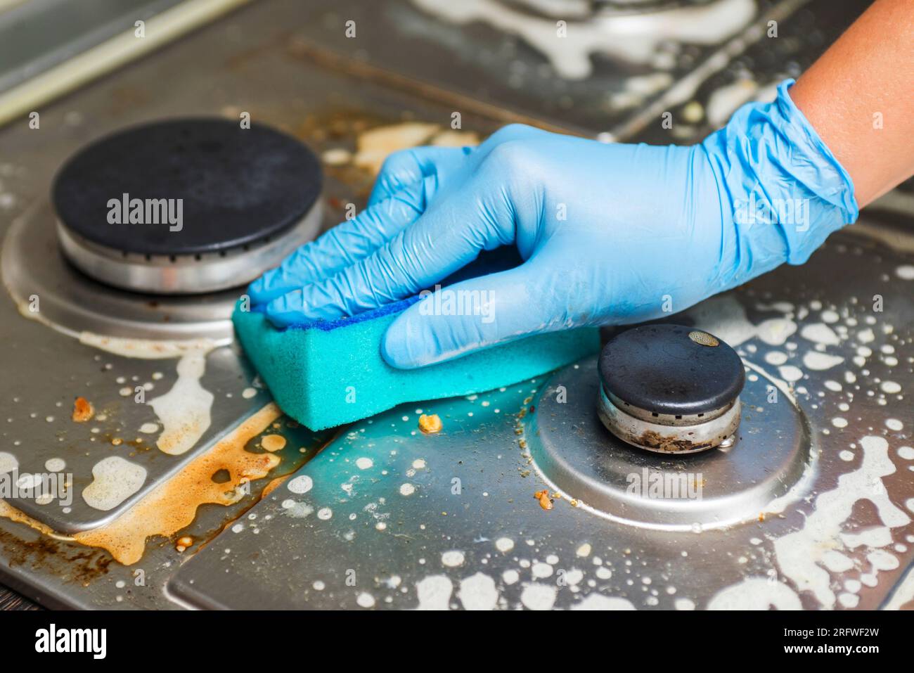 Female hand cleaning gas stove using sponge and detergents Stock Photo ...