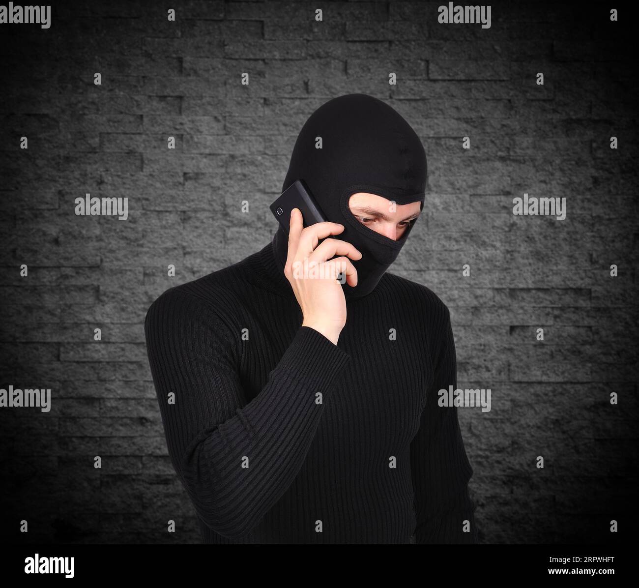 robber talking on phone on a green wall background Stock Photo - Alamy