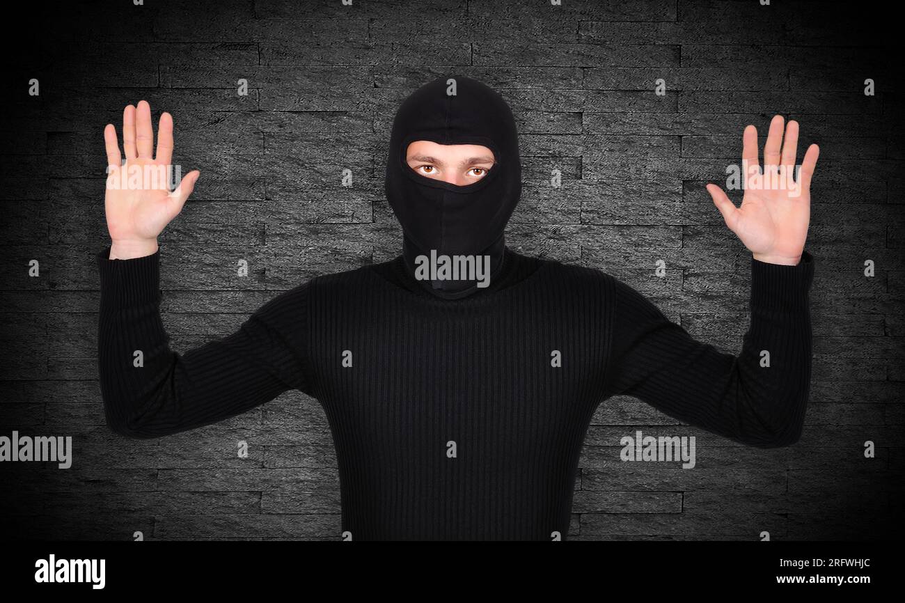robber raised his hands up on gray background Stock Photo - Alamy