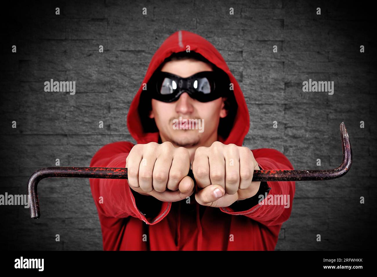 thief with red hoodie holding nail puller Stock Photo - Alamy