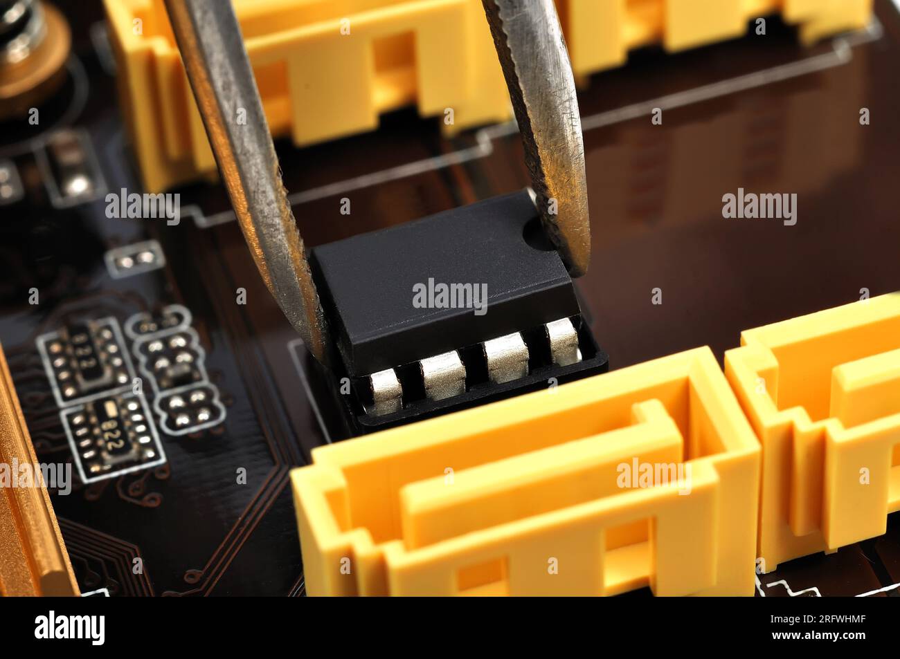 tweezers insert a microchip on the motherboard Stock Photo - Alamy