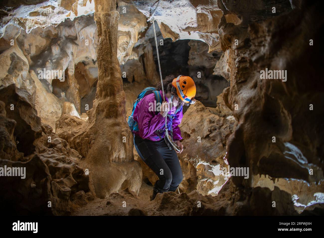 Young woman spelunking inside a cave. Feminism concept. Concept of ...