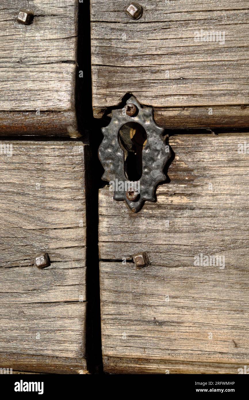 close up old keyhole on wooden boards nailed with blacksmith's nails in ...