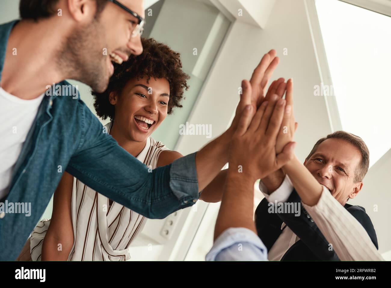 Celebrating success. Business people giving each other high-five and ...