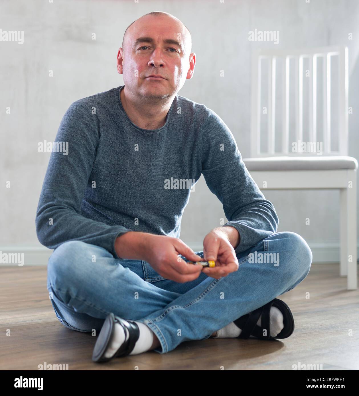 Man poses sitting in the studio Stock Photo - Alamy