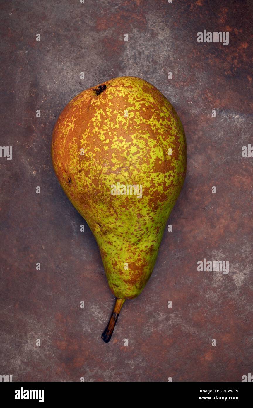 Single ripe Conference pear lying on tarnished metal Stock Photo - Alamy