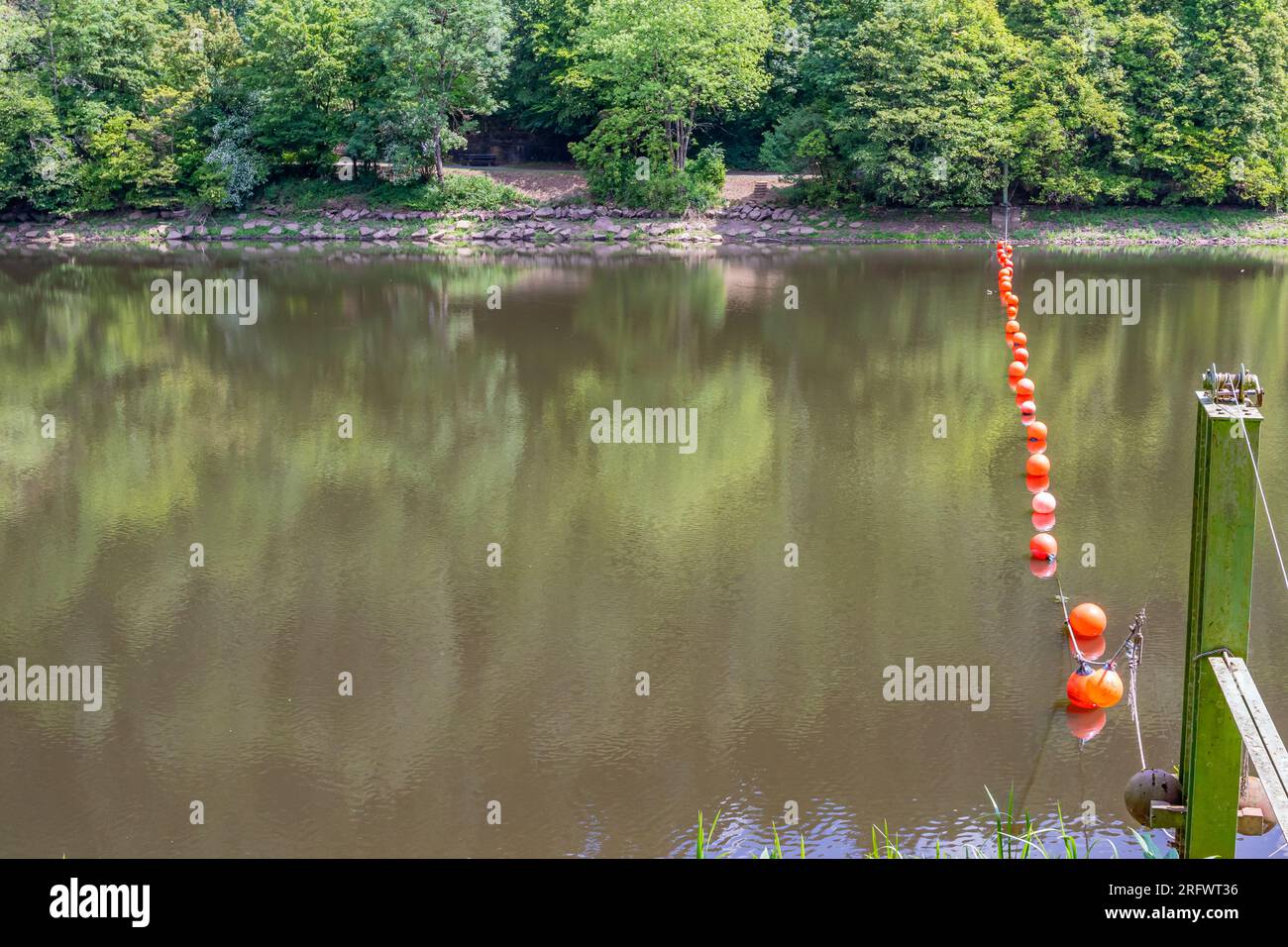 Orange buoys crossing river Prum in Stausee Bitburg reservoir with ...